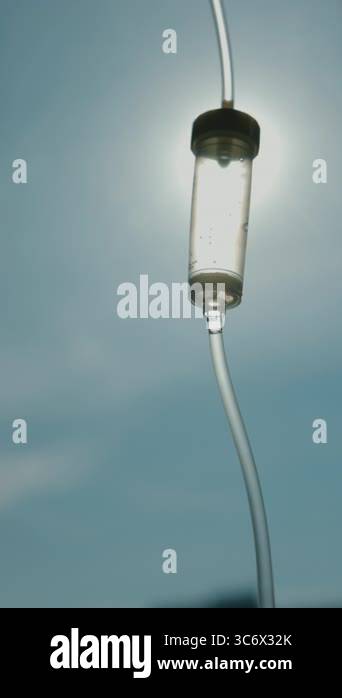 Intravenous drip chamber backlit by sunlight, symbolizing healing, hope ...