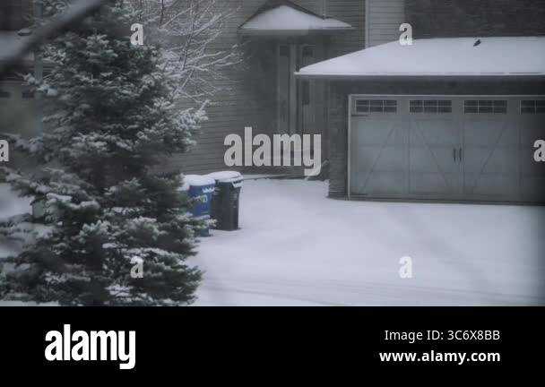 Window view of the snow falling outside on the suburban street in ...