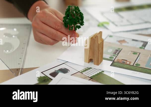 A video of architect using tree and home model to measure blueprint ...