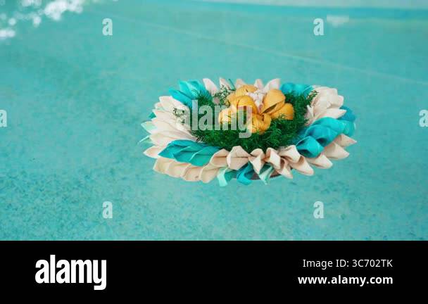 Sacred floating floral tribute with art and candles on the water ...