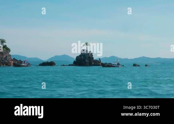 Tropical seascape with a wooden sailboat and green island, beautiful ...