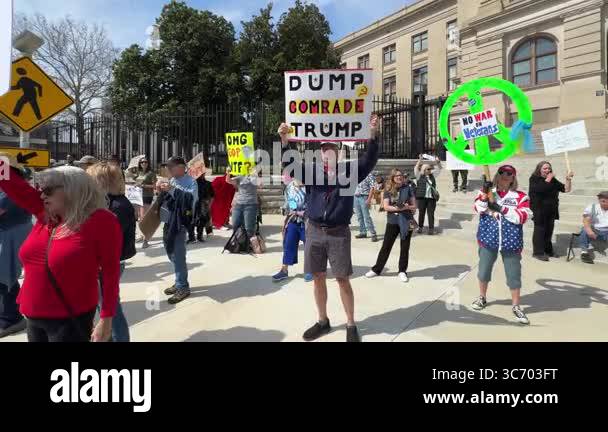 Atlanta, GA / USA March 14, 2025: Tracking shot shows man holding sign ...