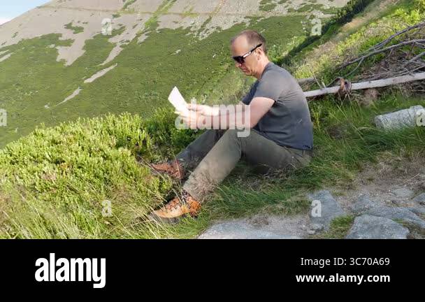 Hiker In The Mountains is Checking Trail On The Map Stock Video Footage ...