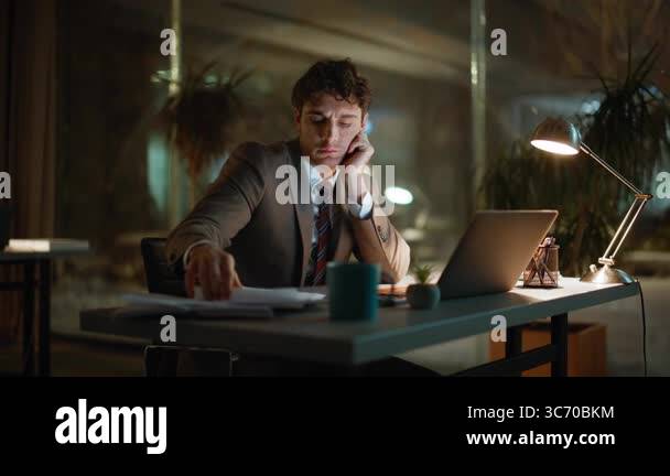 Bored office working waiting finish of work day at late evening room ...