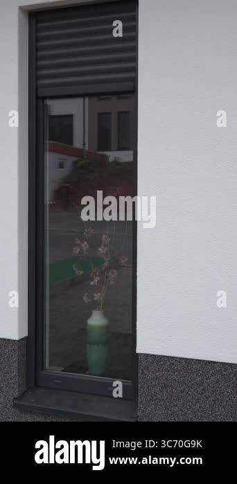 A vertical video showing automatic blinds lowering on the street-facing ...