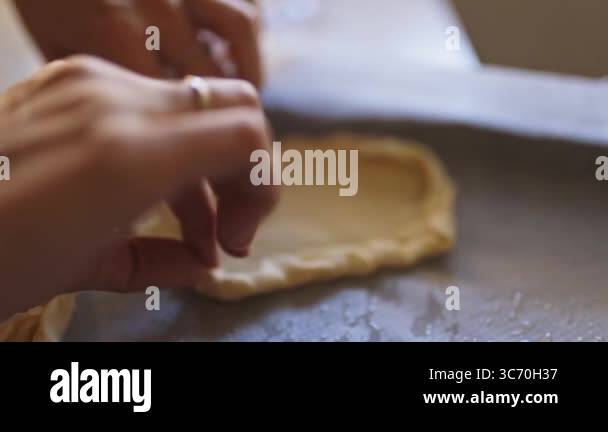 Baker pressing edges of pie crust to seal it on baking sheet Stock ...
