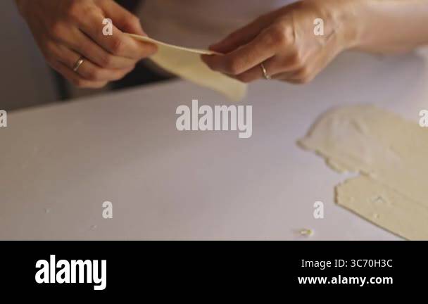 Pastry chef folds dough in half on white table to make heart shaped ...