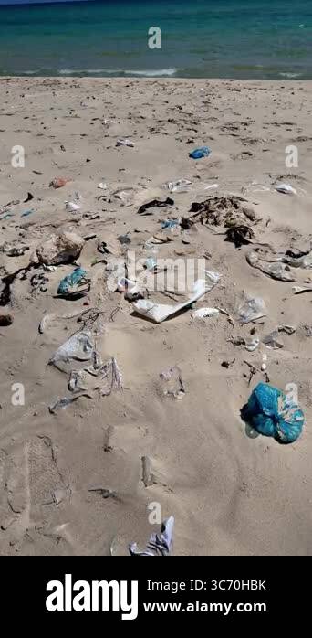 Discarded plastic and trash litter a once-pristine beach, highlighting ...