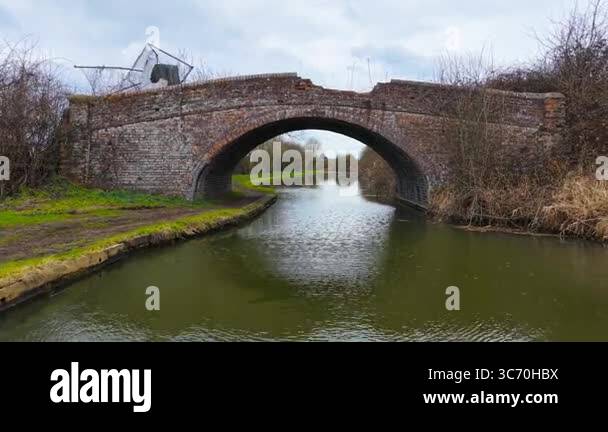 Ancient brick bridge standing over flowing canal. Historic arched ...