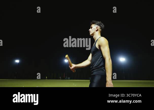 Male Athlete is playing with a relay race baton on the athletics race ...