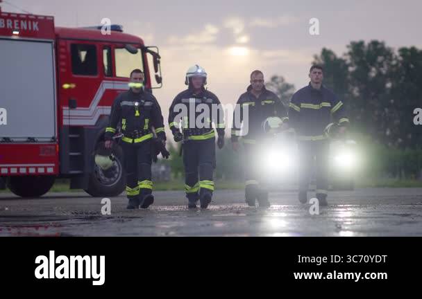 Brave Firefighters Team Walking to the Camera. In Background Paramedics ...