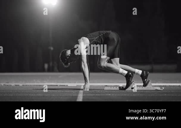 Strong Young Man Starting a Race From Track Starting Blocks Position on ...