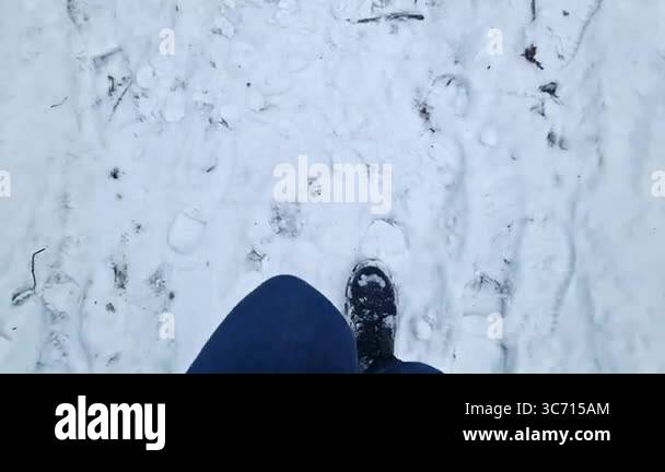 Female legs walking in snow in winter, first person view. Close-up of ...