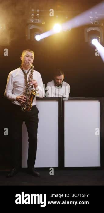 Vertical Video of DJ Playing Music in Nightclub. Saxophonist man with ...