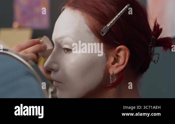 Close-up shot of smiling gen Z girl dabbing white foundation with ...