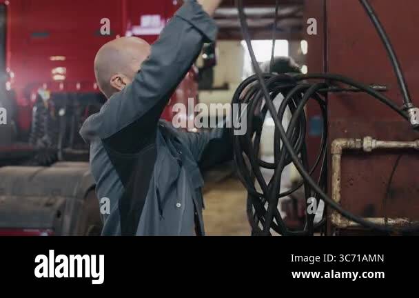 Side view medium shot of confident middle-aged Caucasian male mechanic ...