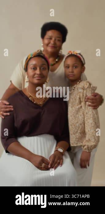 Vertical family group portrait shot of grandmother, mother, and ...