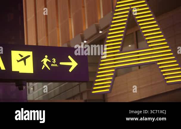 Signage at the airport guides passengers towards the boarding area ...