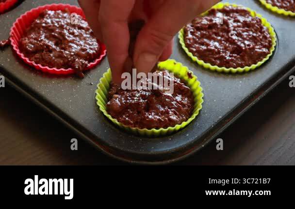 raw chocolate banana muffins in a muffin tray ready to bake Stock Video ...