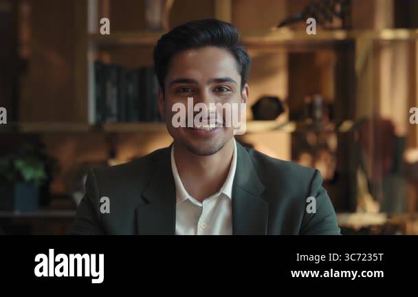Portrait of positive Indian man employee waves hand and nods on ...