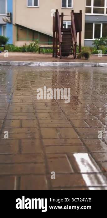 Raining. close-up. raindrops fall on wet street tiles against ...