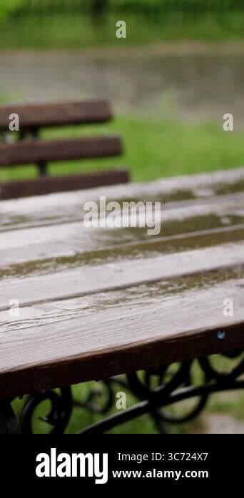 Empty table and the bench are drenched, wet under rain, on the playground, in the yard. a heavy ...
