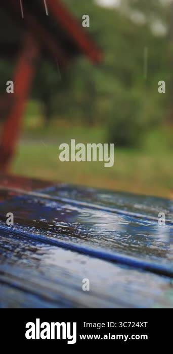 Rain, puddles. raining in the park. close-up. raindrops fall on wooden ...