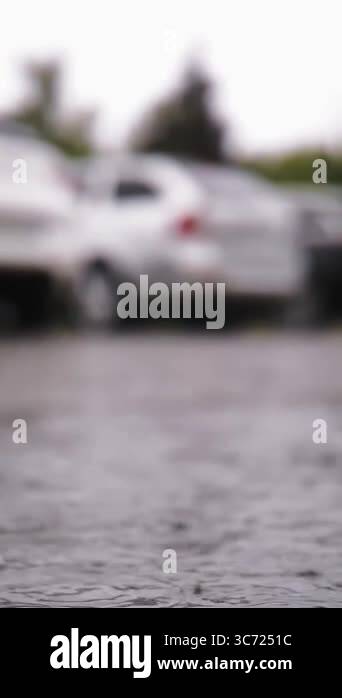 Rain, puddles. raining on parking lot. close-up. raindrops fall into ...