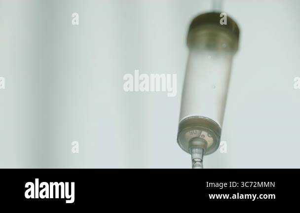 Intravenous drip chamber with fluid drops, representing medical care ...