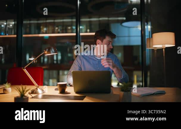 Businessman frustrated financial loss looking laptop at night office ...