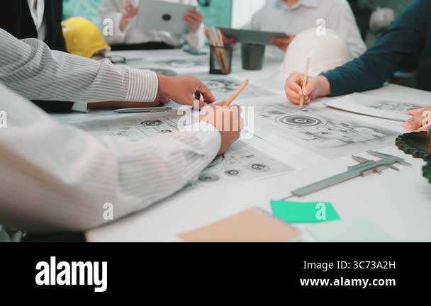 A diverse group of professionals engages in a collaborative design process, using sketches and ...