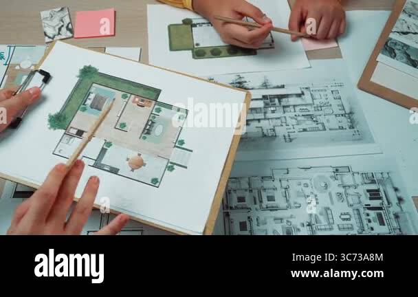 A vibrant workspace displays various architectural plans and sketches ...