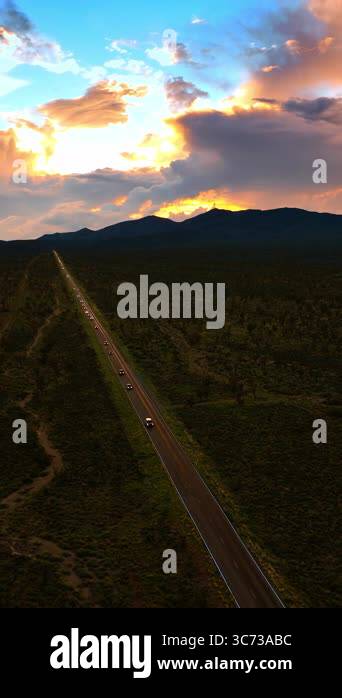 Straight highway passing the Death Valley after sunset. Cars with ...