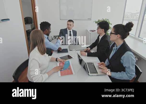 Handheld medium shot of male CEO of company entering meeting room and ...