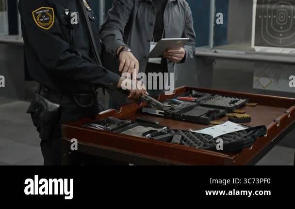 Medium tilt-up of young black male police officer or security guard in ...