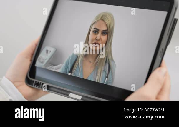 A person is sitting with a tablet in a medical environment, actively ...