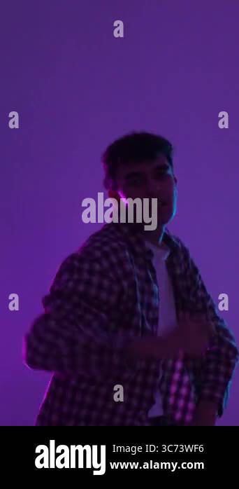 Energetic male dancer showcasing dynamic moves under vibrant neon ...