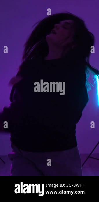 Energetic dancer practicing modern moves under vibrant neon lights, showcasing fluid movements ...