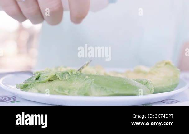 Close-Up of Avocado Halves Being Sprinkled with Salt and Ground Pepper ...