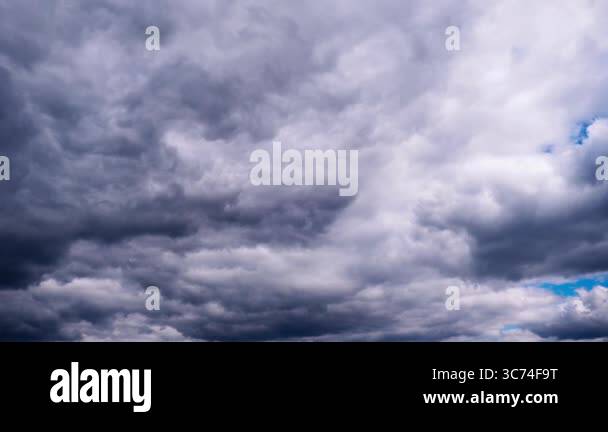 Timelapse of dark storm clouds gathering and spreading over a bright ...