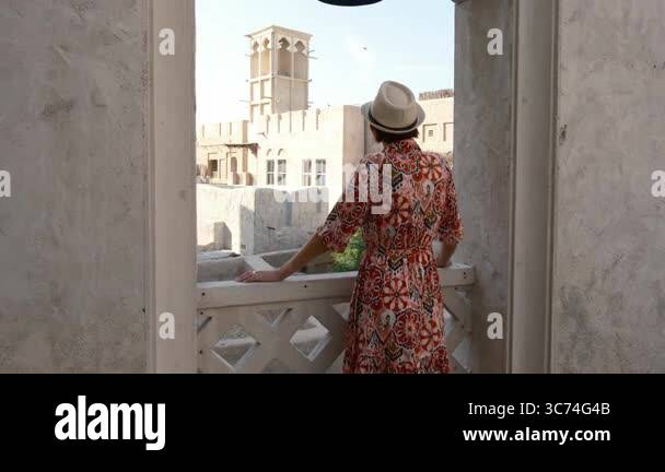 Young woman in ethnic dress and hat exploring Al Seef Park in Dubai ...