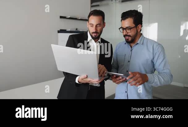Multiethnic professionals, male colleagues standing in modern office ...