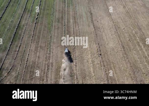 Tractor top down view raking hay into rows in a dusty field Stock Video ...