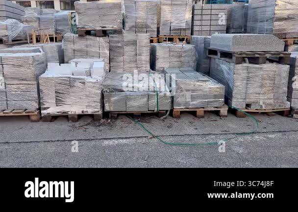 In a spacious warehouse, stacks of wrapped pallets are organized for ...