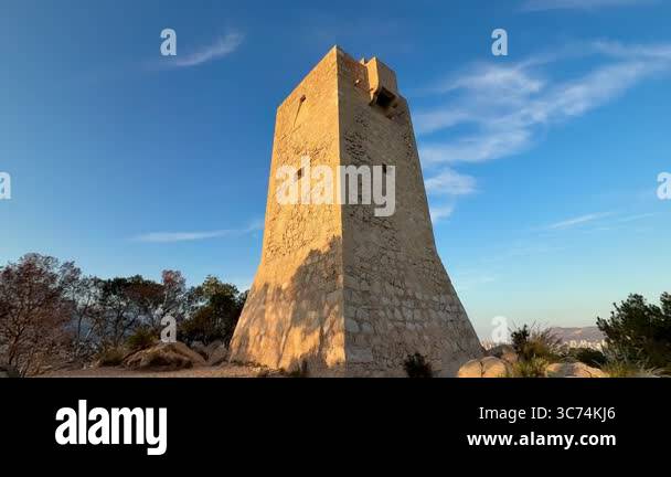 A stunning view of an ancient tower overlooking the sea during golden ...