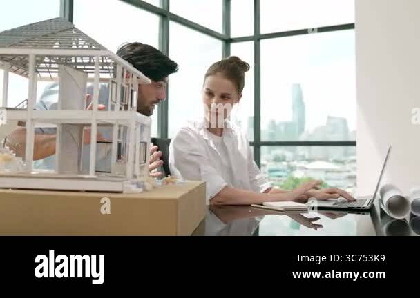 Smart architect engineer inspect house model while colleague using laptop analysis data ...
