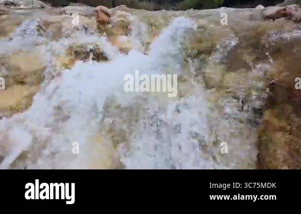 An underwater perspective shows water falling between rocks into a ...