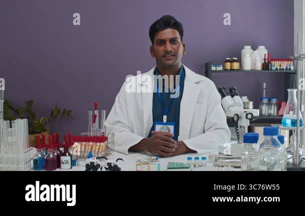 Static shot of Indian scientist recording educational video at table ...