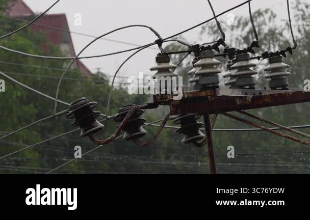 A detailed view of power lines and insulators while experiencing heavy ...