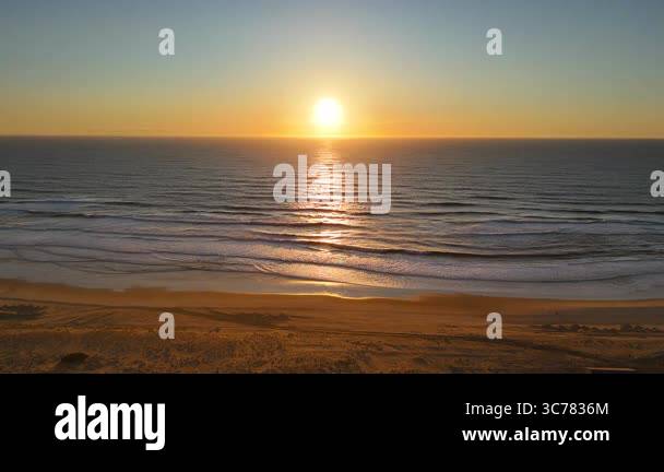 Drone captures golden sunset over ocean, gliding above tranquil waves ...